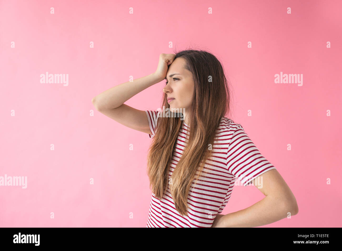 Upset girl holds hand over head. She has a headache or she has made a ...