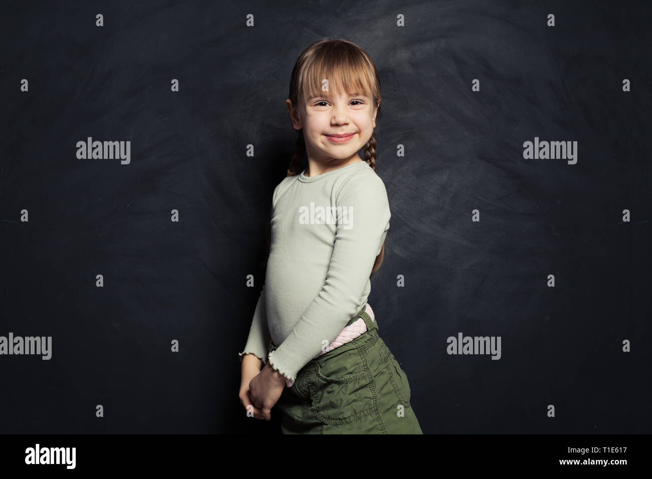 Mischievous child on school classroom background. Cute funny child girl ...