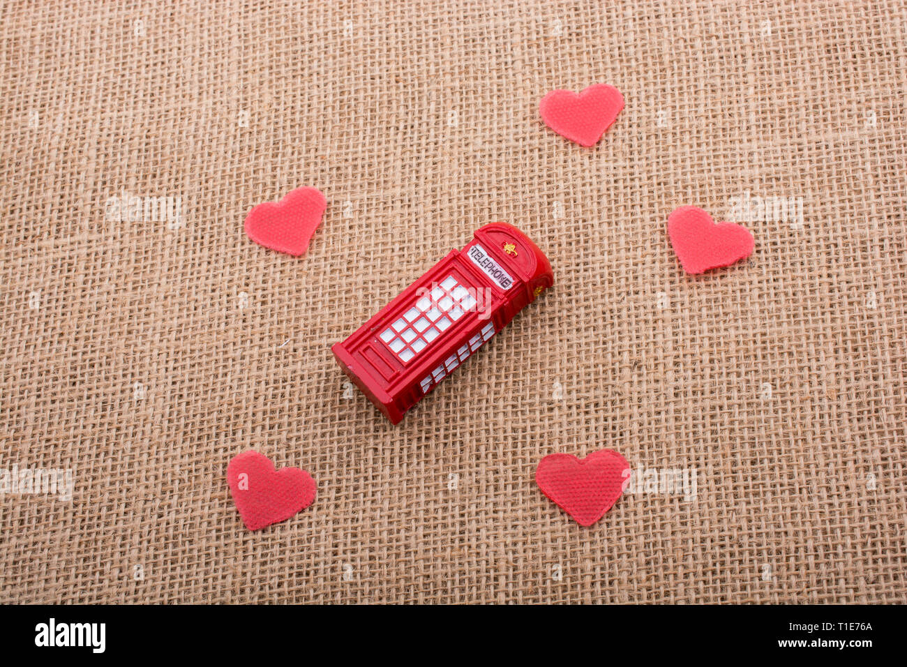 Red hearts around red color phone booth on canvas Stock Photo - Alamy