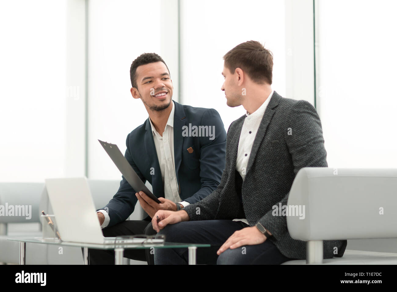two business people discuss business documents at a meeting in the ...