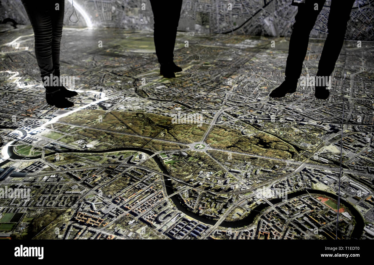 Berlin, Germany. 25th Mar, 2019. People walk over an illuminated aerial ...