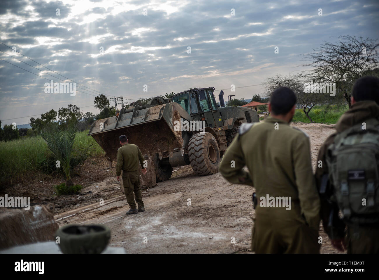 26 March 2019, Israel, Nahal Oz: Israeli soldiers watch a bulldozer ...