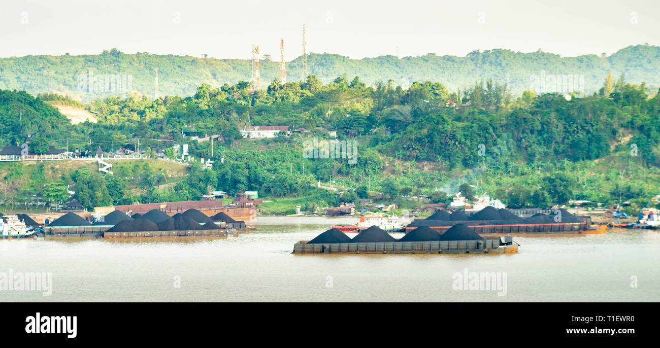 view of traffic of tugboats pulling barge of coal at Mahakam River ...