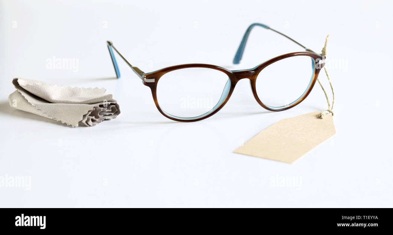 Closeup of eyeglasses and lens cloth with empty tag isolated on white ...