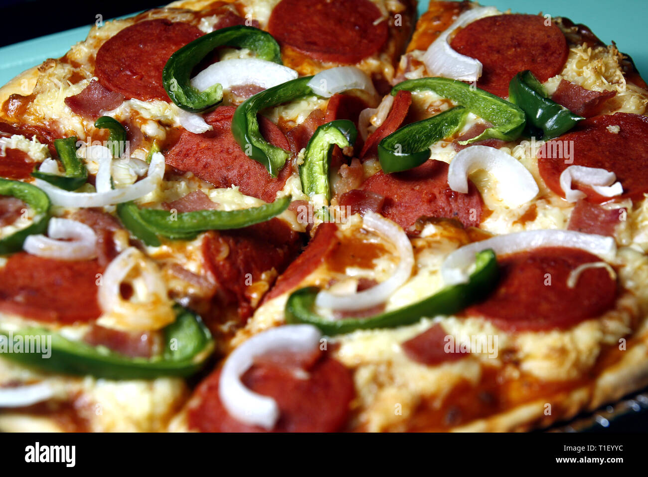 Photo of a ham, pepperoni, cheese with green bell pepper pizza Stock ...