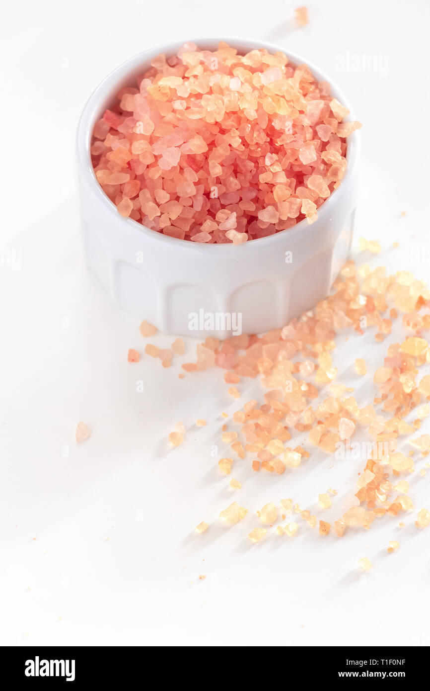 Big Crystals of pink Himalayan salt in jar. White background. Top view ...