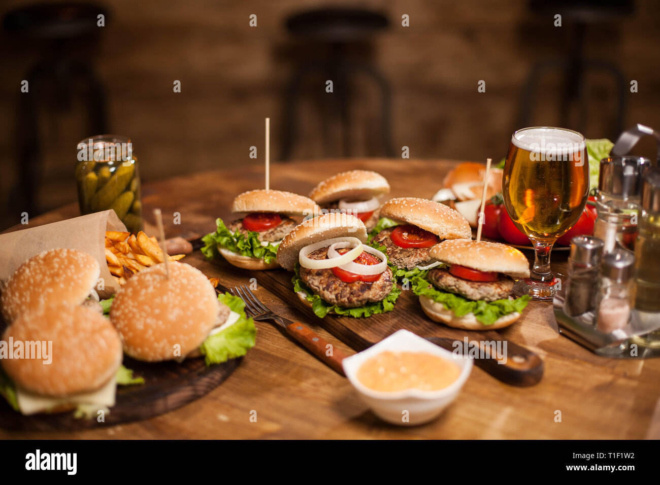 Lots of delicious burgers lying on a table in a vintage pub or ...