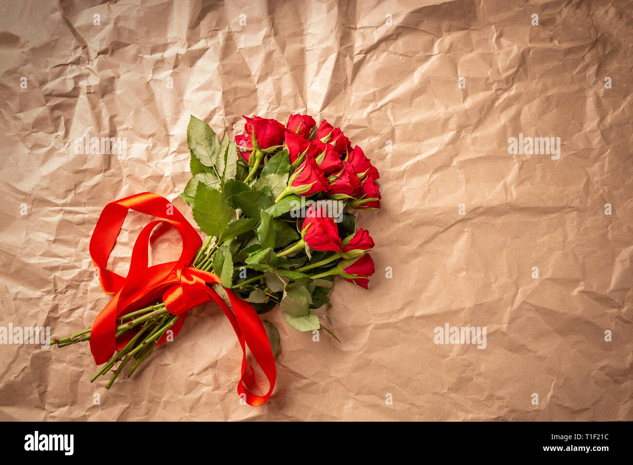 Red rose bouquet on wrapped paper background Stock Photo - Alamy