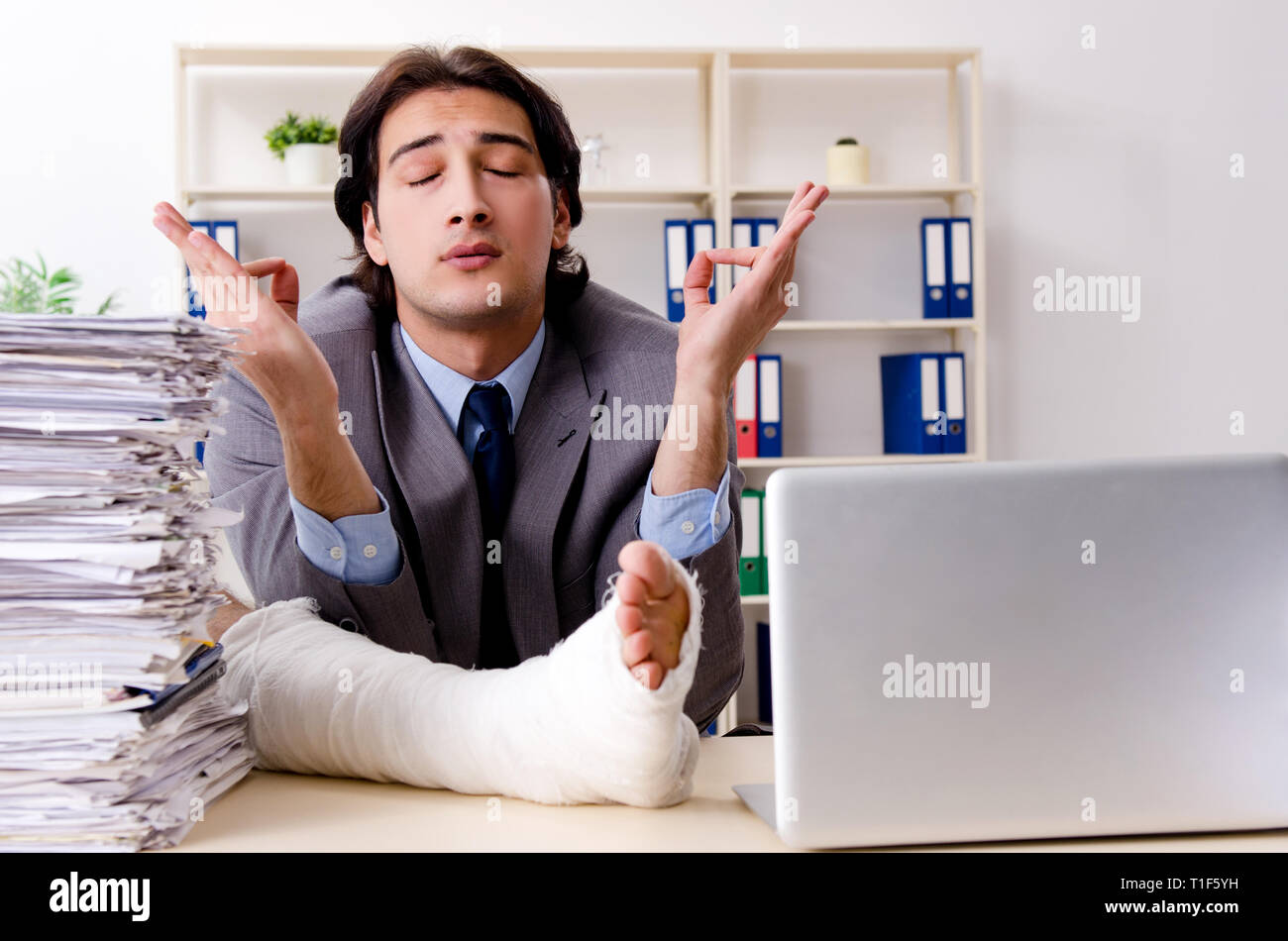 Leg injured employee working in the office Stock Photo - Alamy