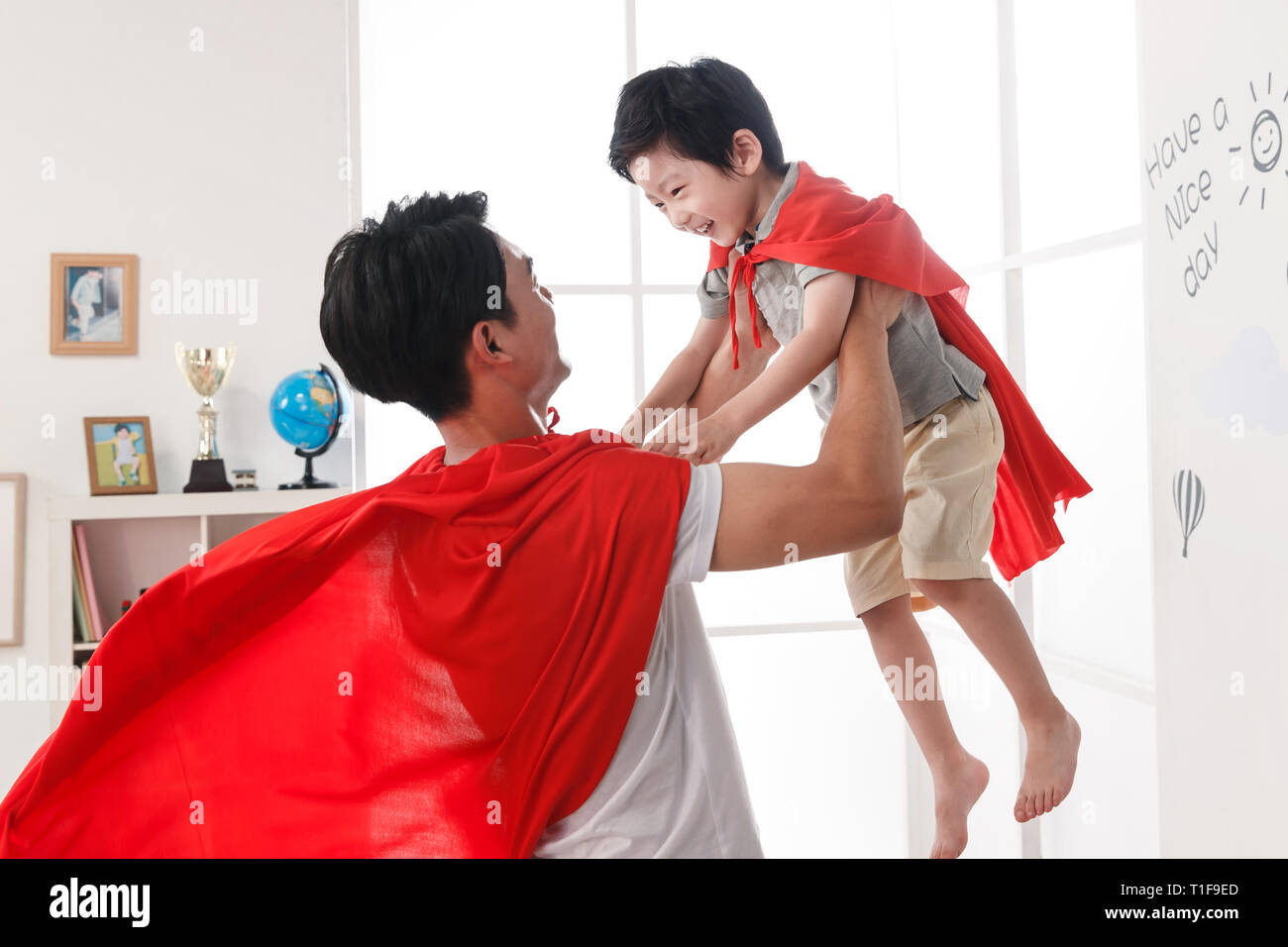 Happy father and son playing a superman Stock Photo - Alamy