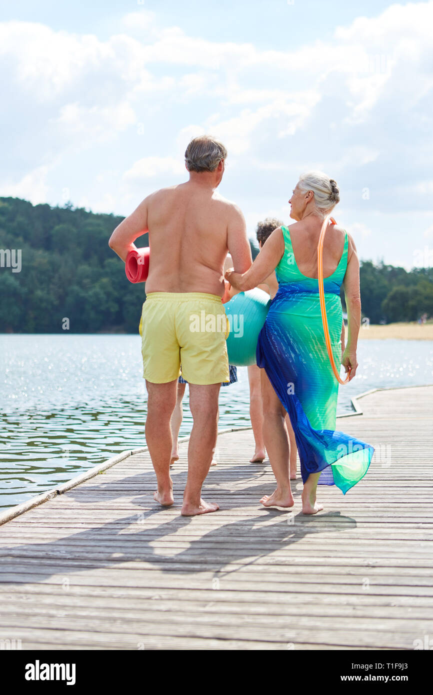 Seniors go swimming together in the summer holiday at the lake or at ...