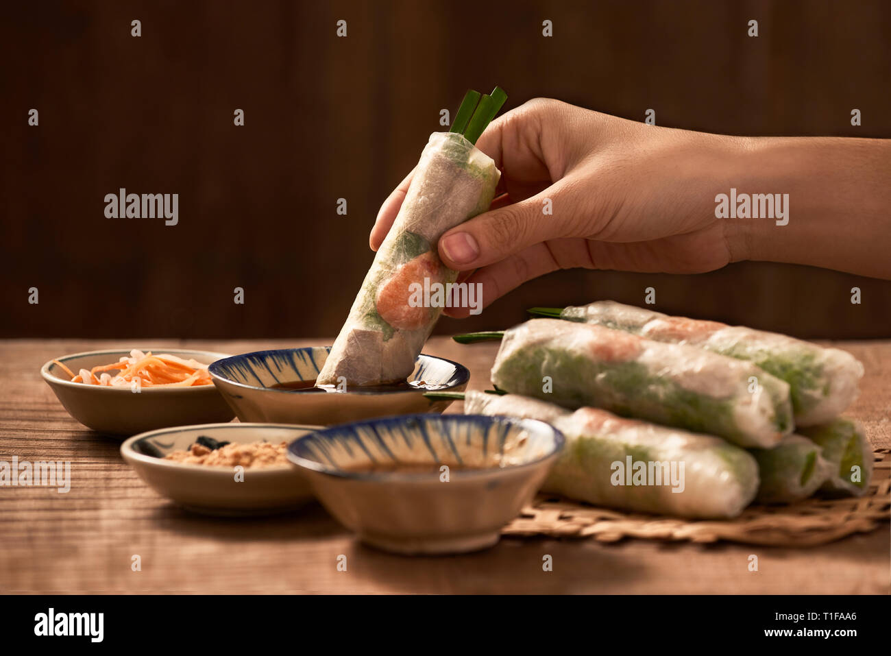 Hand dipping vegetarian rice paper rolls into the soy sauce Stock Photo ...