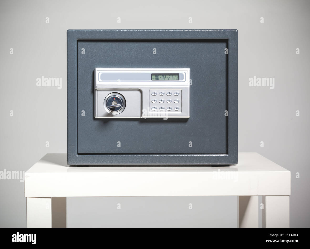 Closed safe on grey background Stock Photo - Alamy