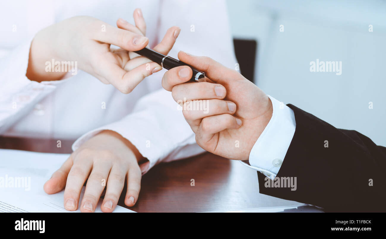 Business women giving a pen to businessman for contract signing ...