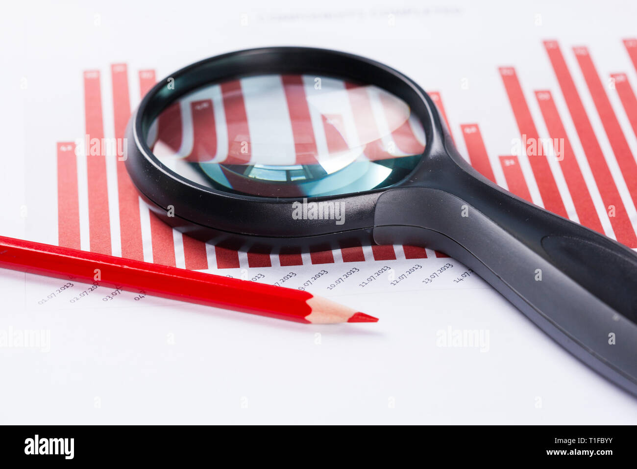 Magnifying glass over financial graph hi-res stock photography and ...