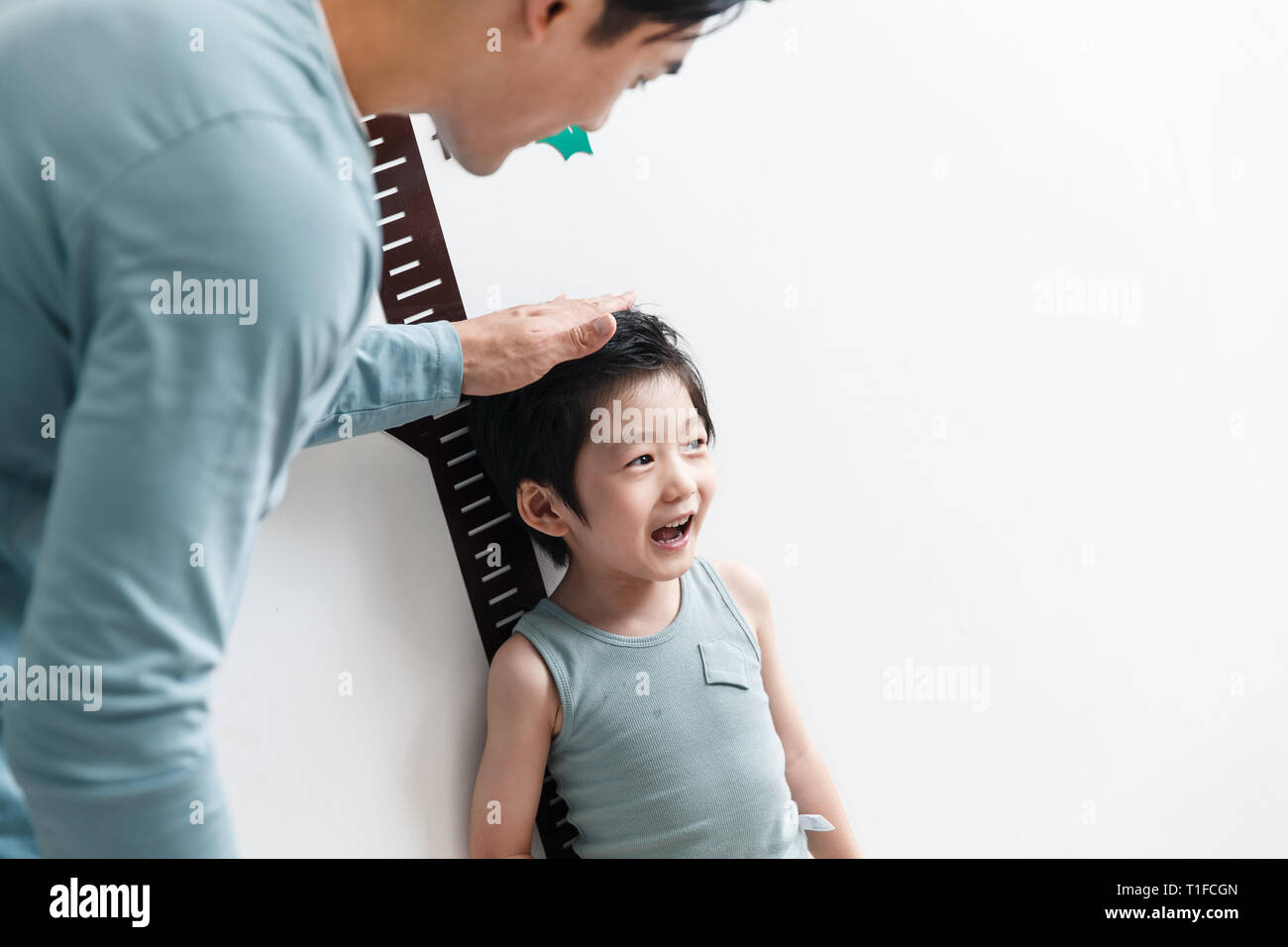 Father measuring son height ruler hi-res stock photography and images ...