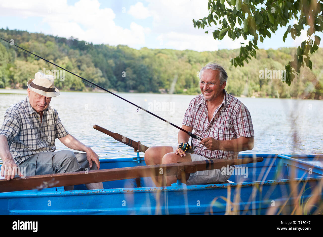 Two relaxed seniors in the boat fishing on the lake at the weekend in ...