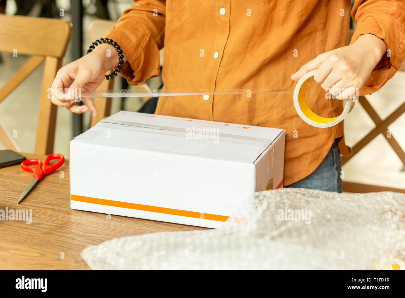 Startup small business woman owner packing cardboard box at workplace ...