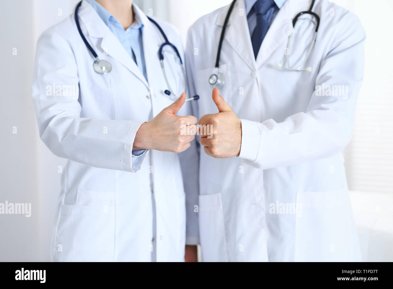 Team of unknown medicine doctors showing OK sign with thumb up close up ...