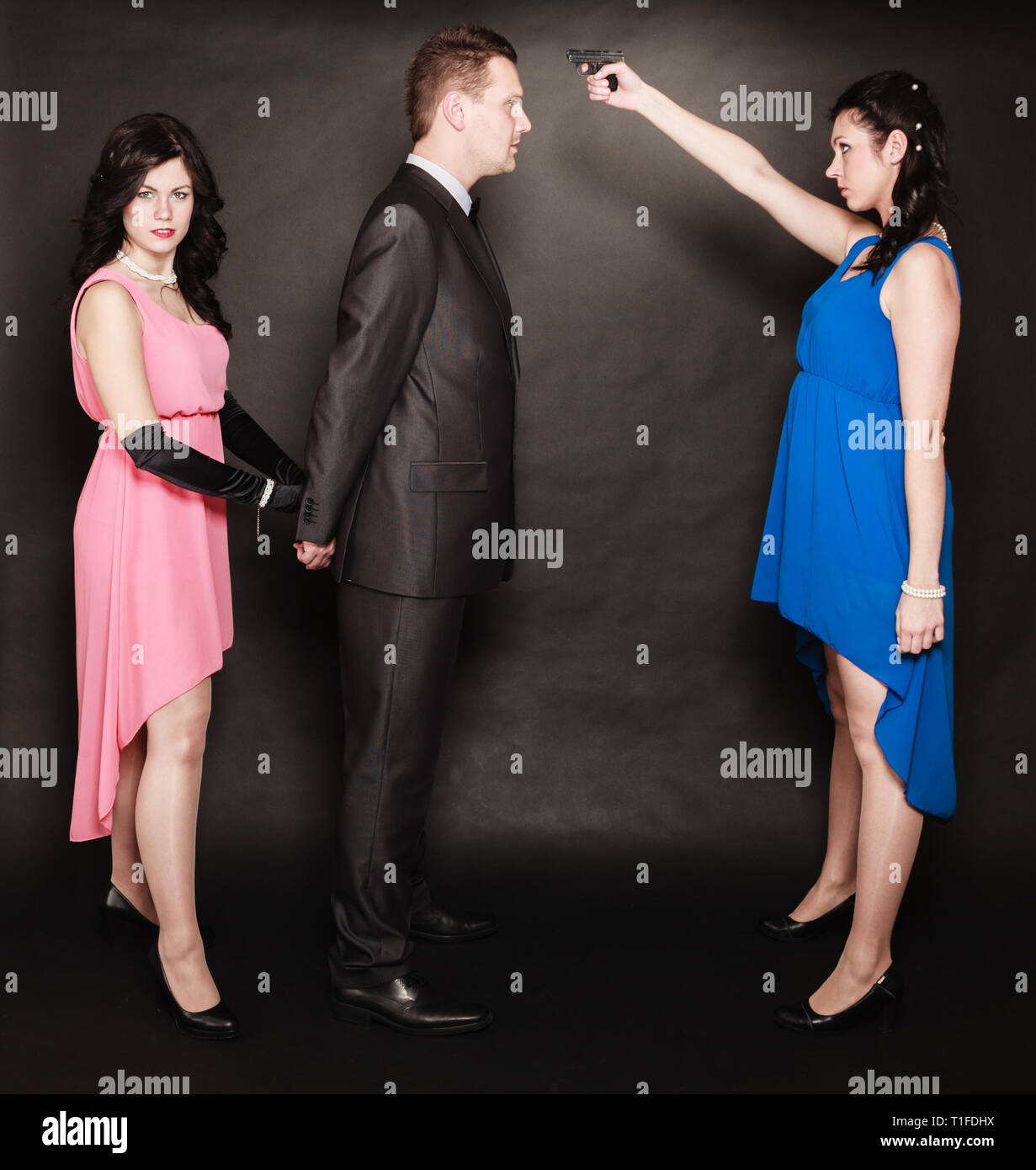 Scene of violence with firearm between men and women. Elegant lady ...