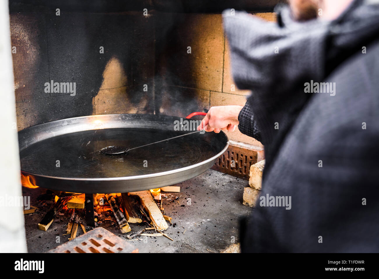 Cooking and making a traditional Spanish Paella over open fire ...