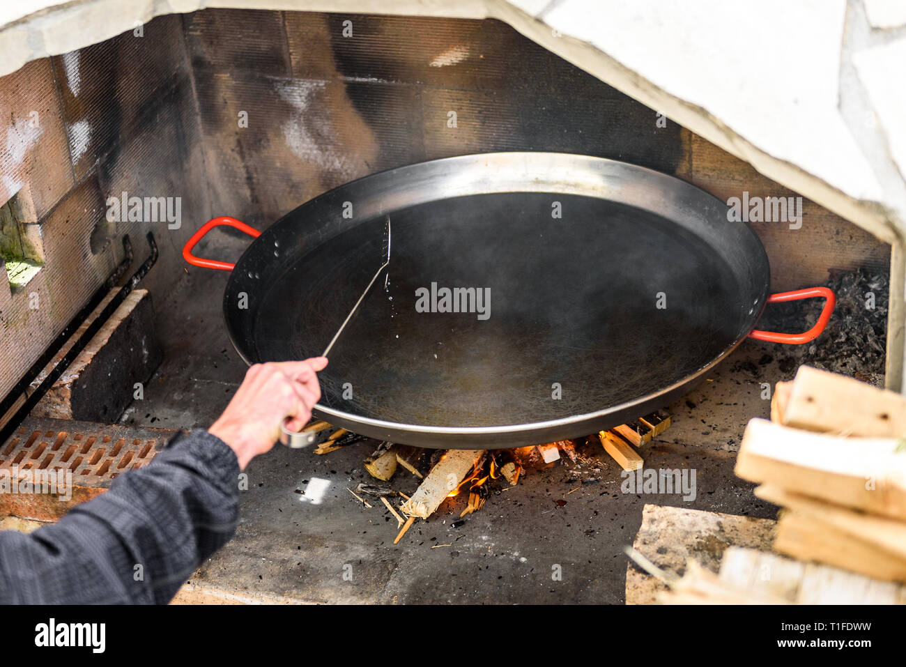 Cooking and making a traditional Spanish Paella over open fire ...