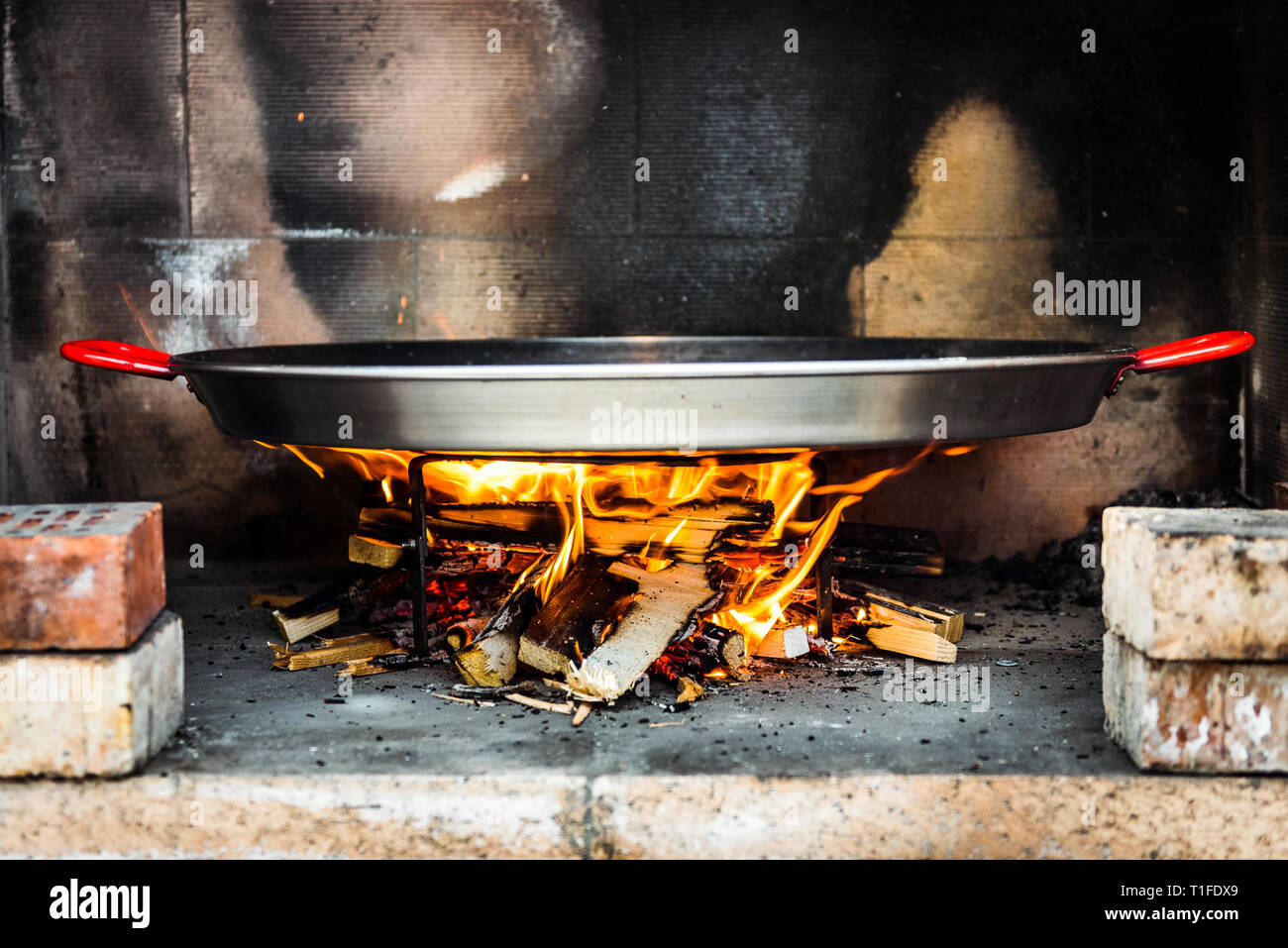 Cooking and making a traditional Spanish Paella over open fire ...