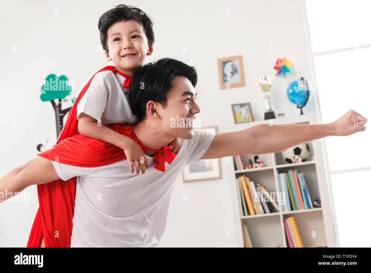 Happy father and son playing a superman Stock Photo - Alamy