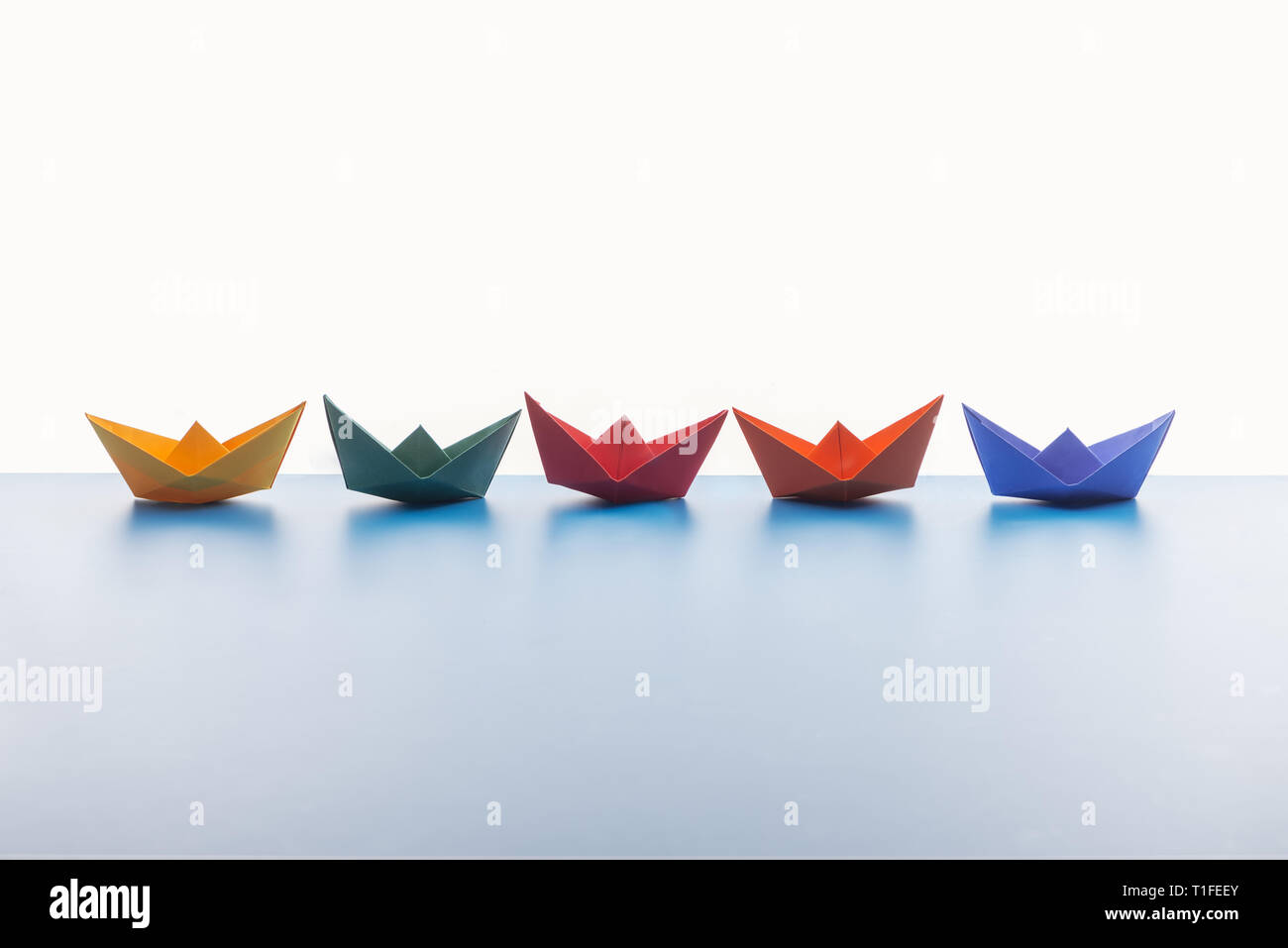 Colorful paper boats on light surface on white background Stock Photo ...