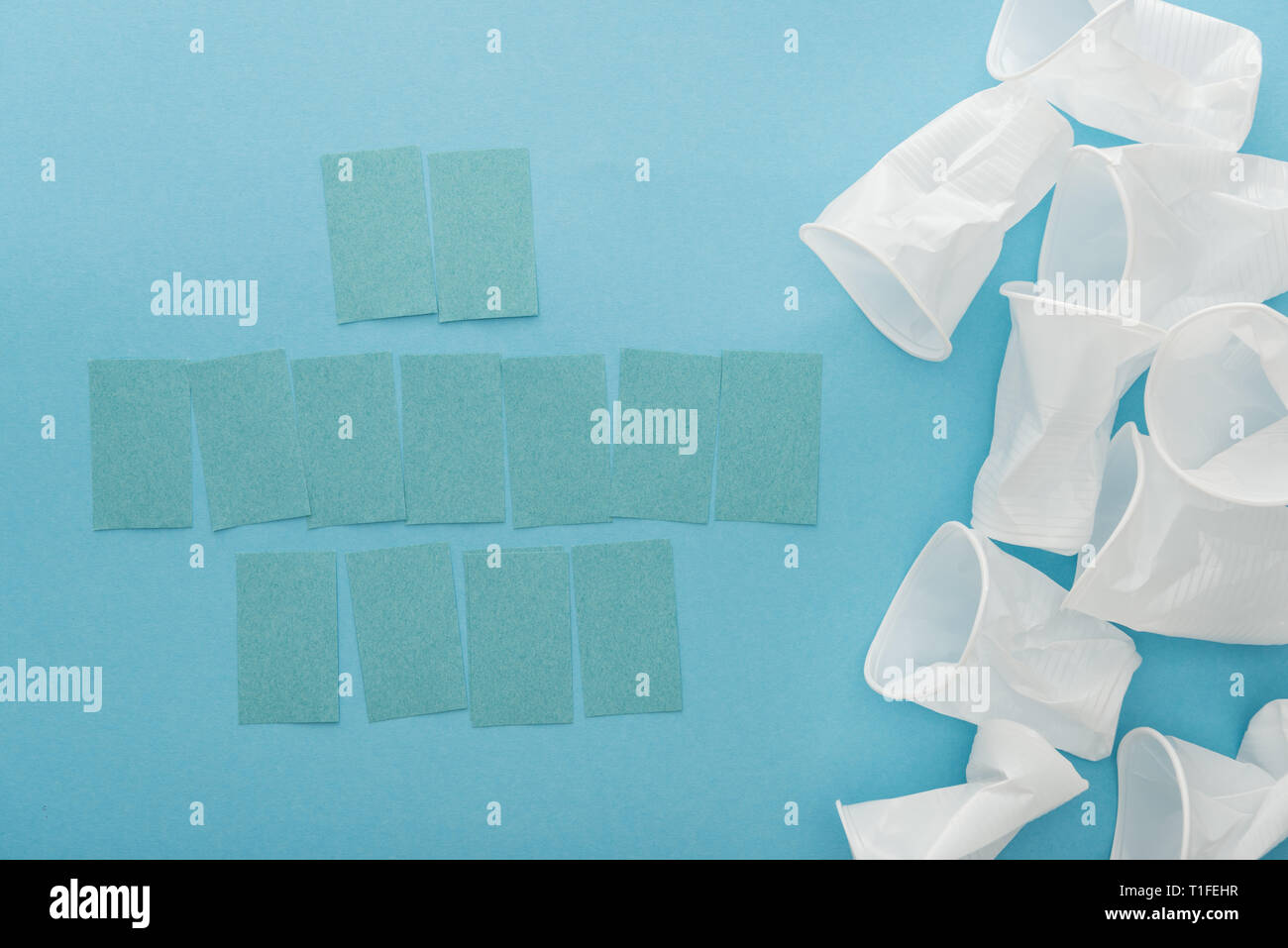 top view of white plastic cups and empty sticky notes with copy space ...