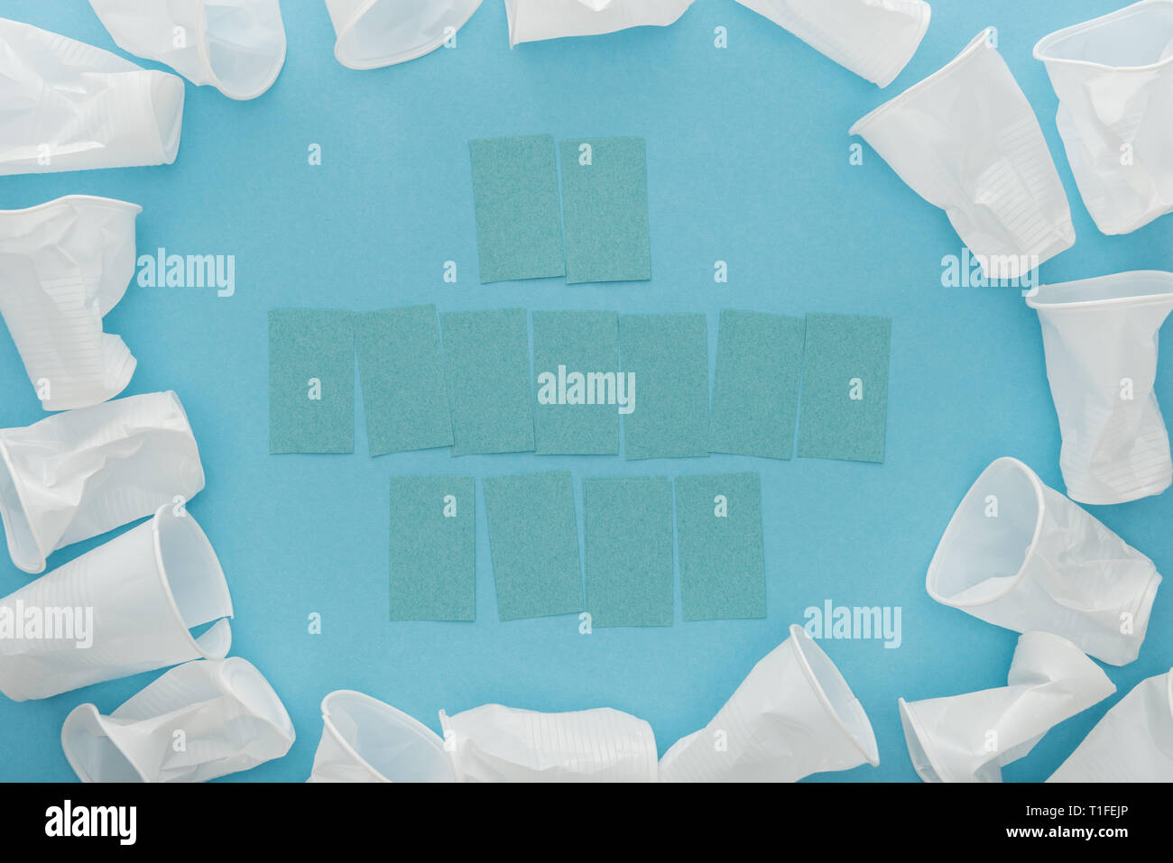 top view of white plastic cups and empty sticky notes with copy space ...