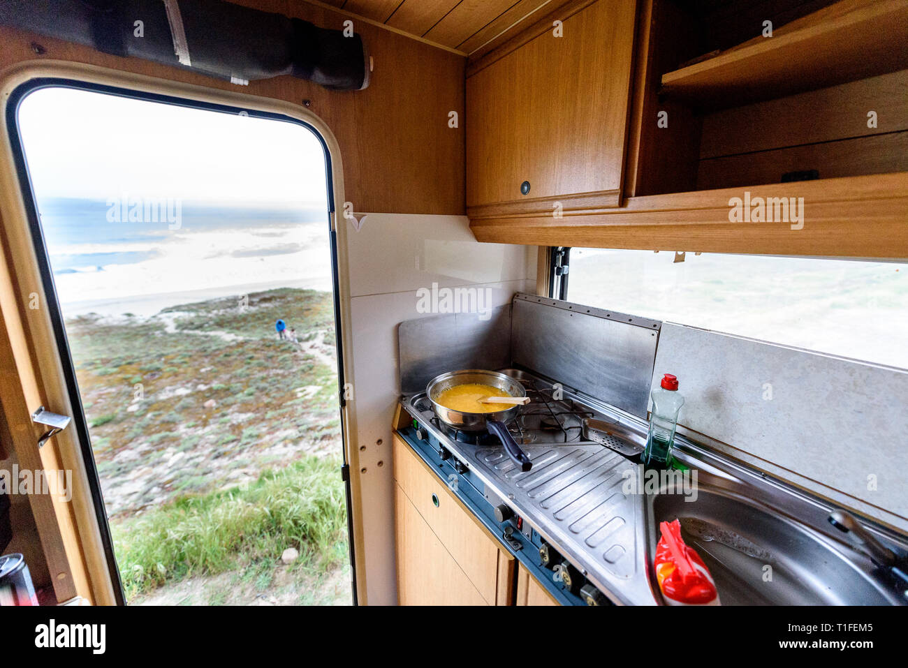 Cooking dinner or breakfast in camper RV with beach view. Preparing ...