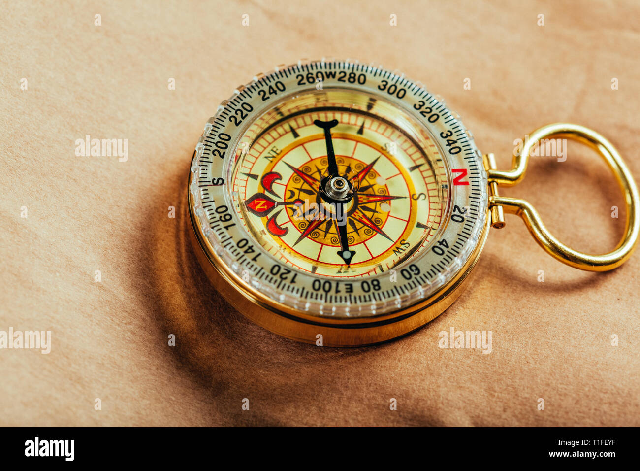 Antique brass compass over old paper Stock Photo - Alamy