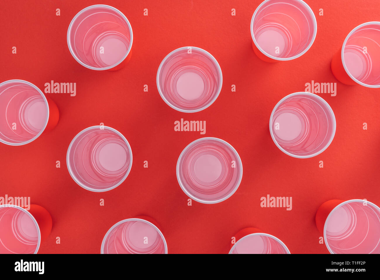 top view of bright and colorful plastic cups on red background Stock ...