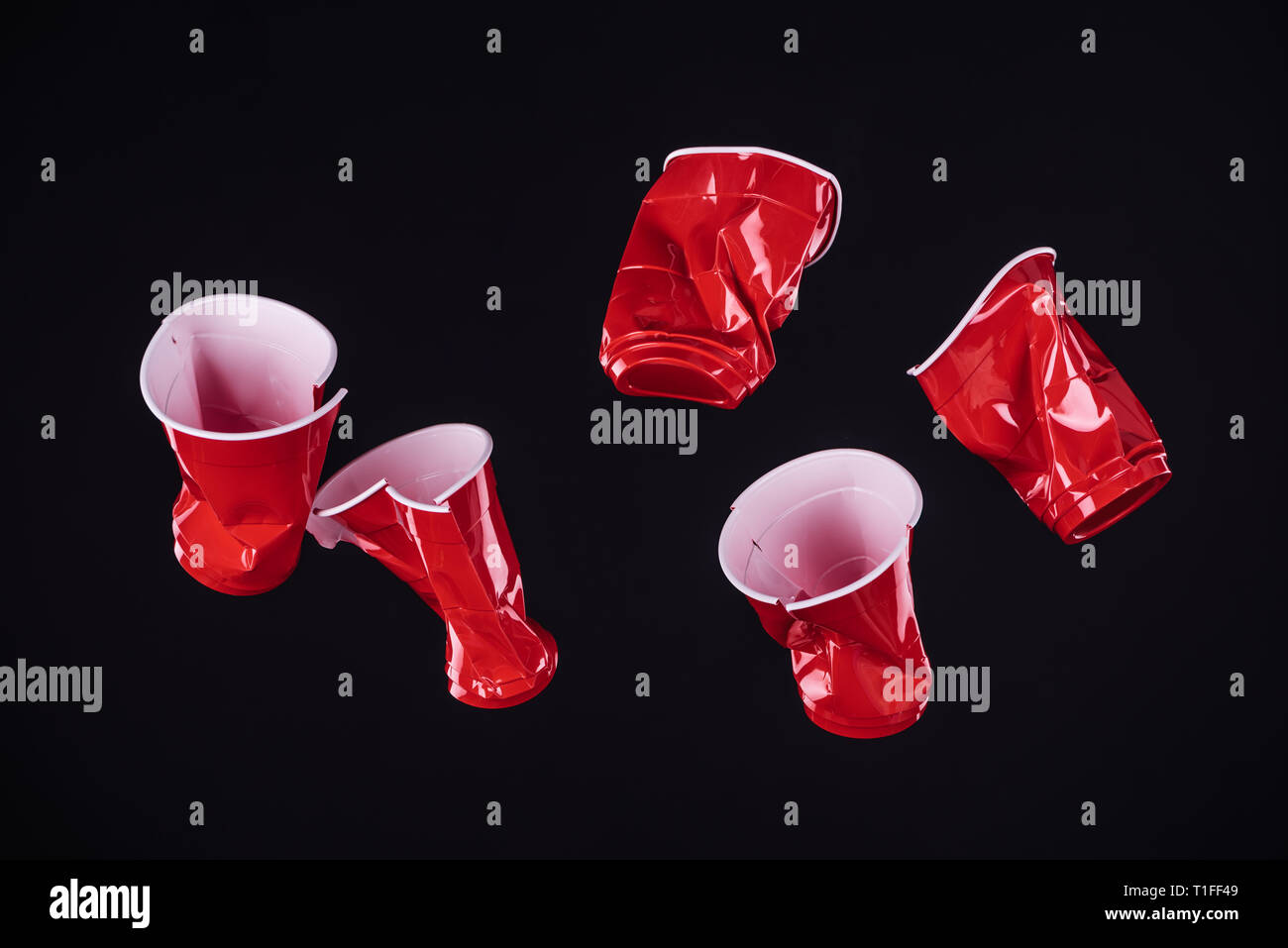 top view of bright and colorful, red plastic cups isolated on black ...