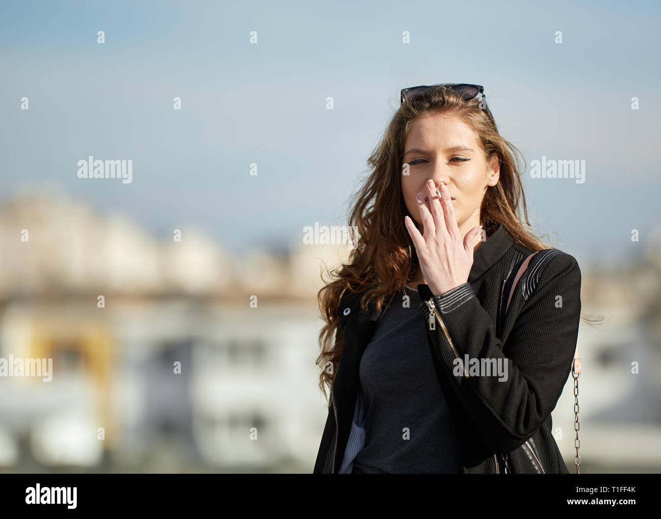 Portrait of a woman smoking a cigarette in urban environment Stock ...