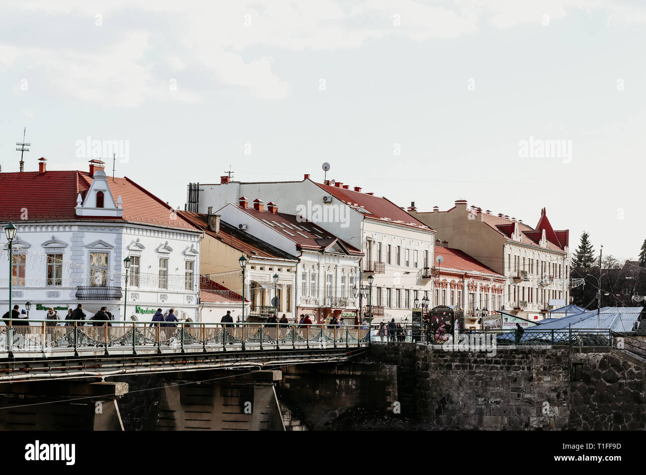 Uzhgorod. City landscape with stone houses with orange roofs, bridge ...