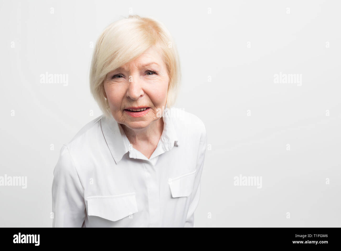 Old and tricky woman is very attentive to details. She is trying to ...