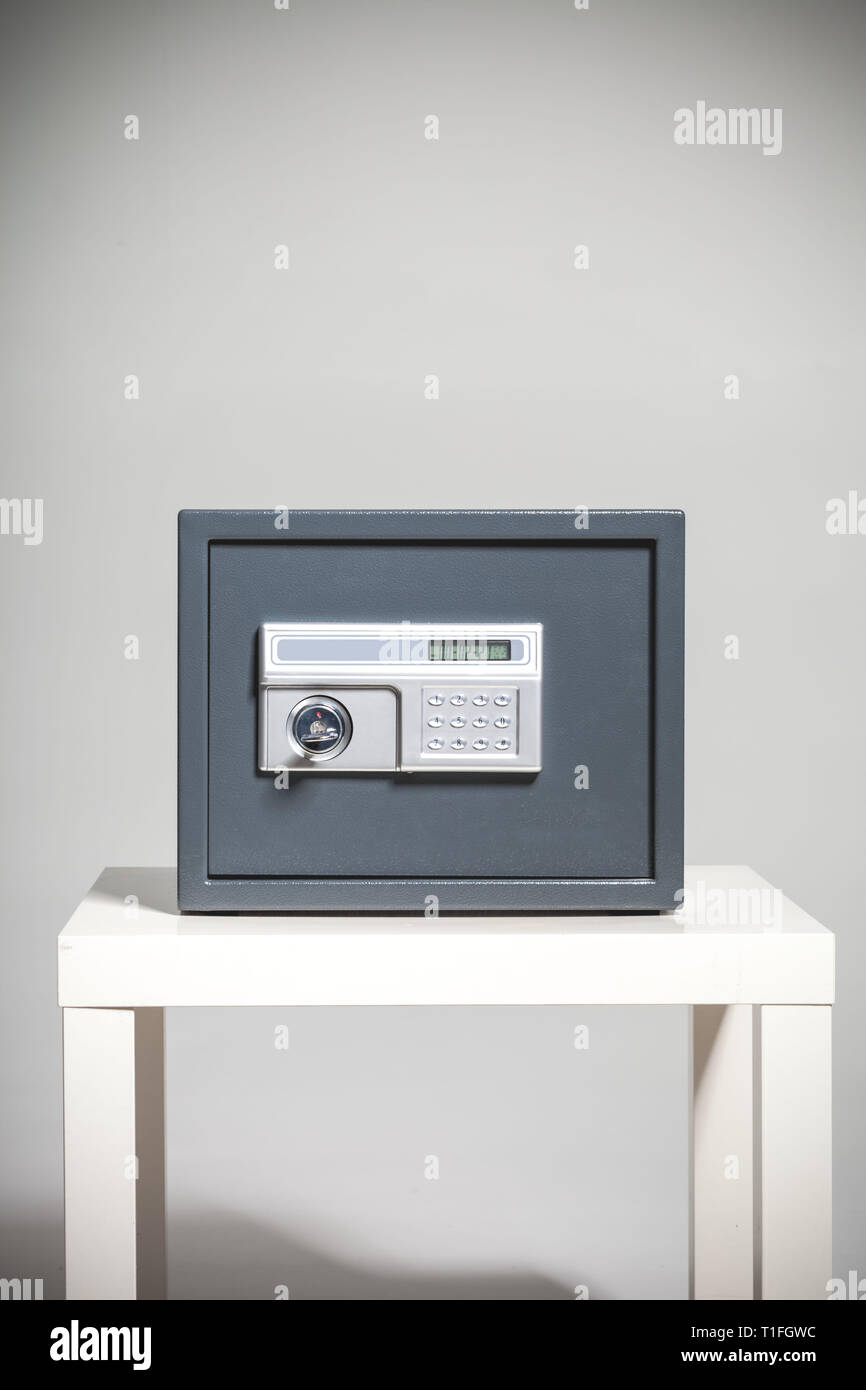 Closed safe on grey background Stock Photo - Alamy