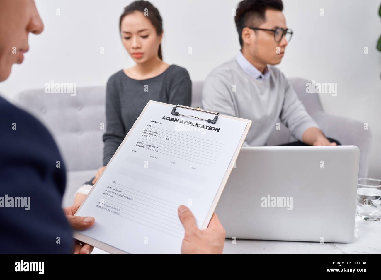 Young angry couple of cheated investors holding papers arguing with ...