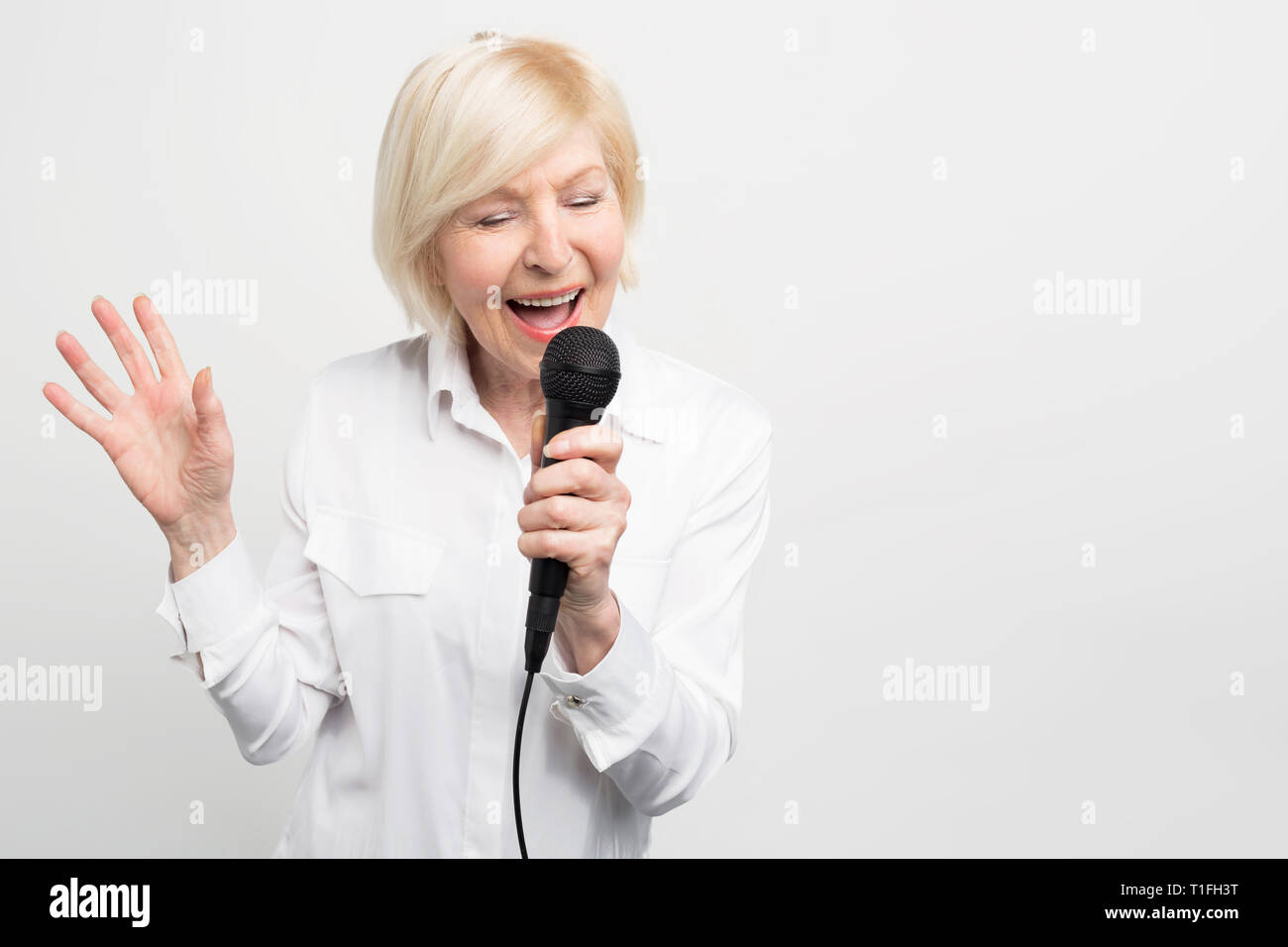 Nice woman standing on the left side of the frame and singing her ...