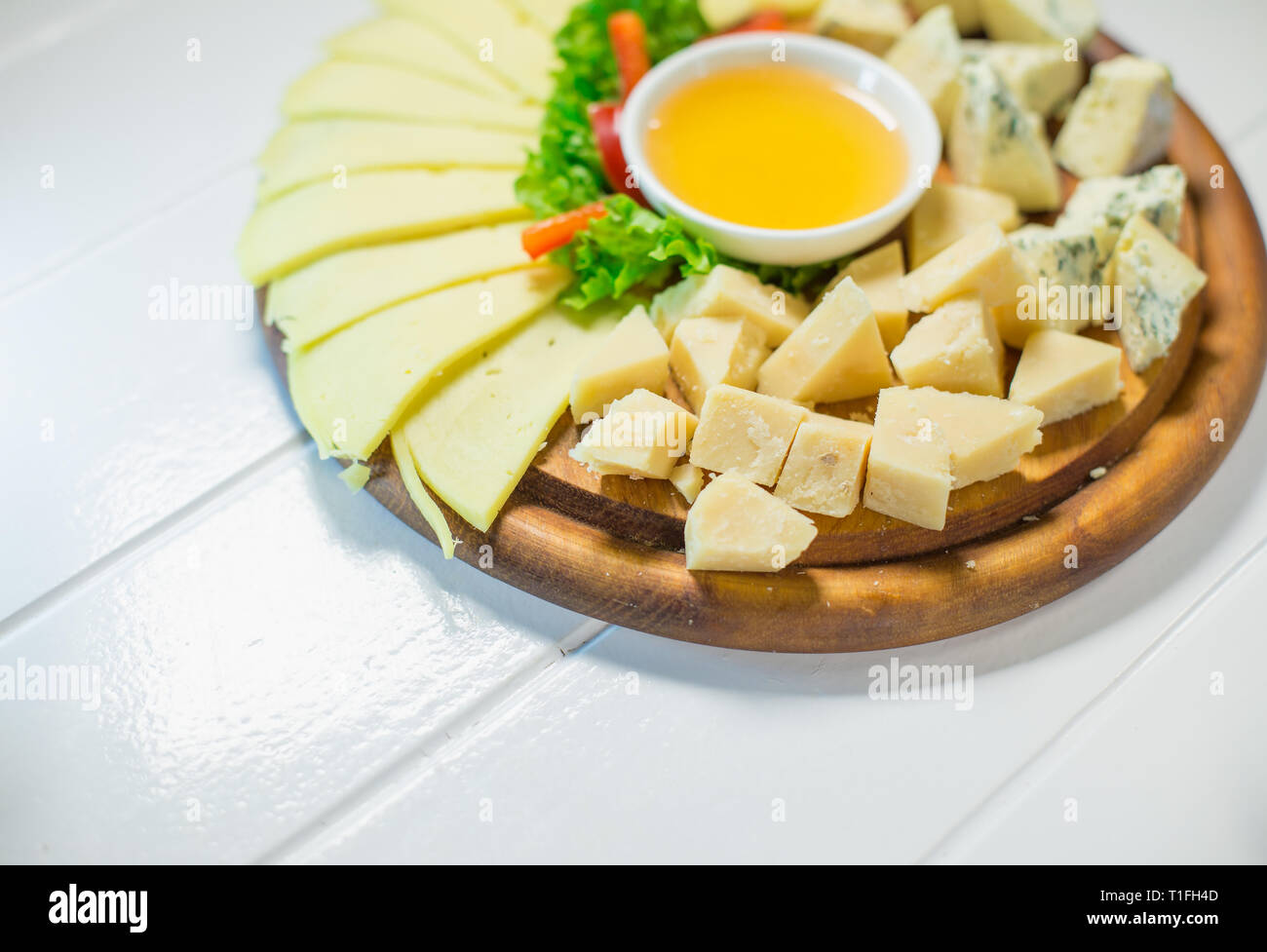 Different cheese on the table with honey and vegetables Stock Photo - Alamy