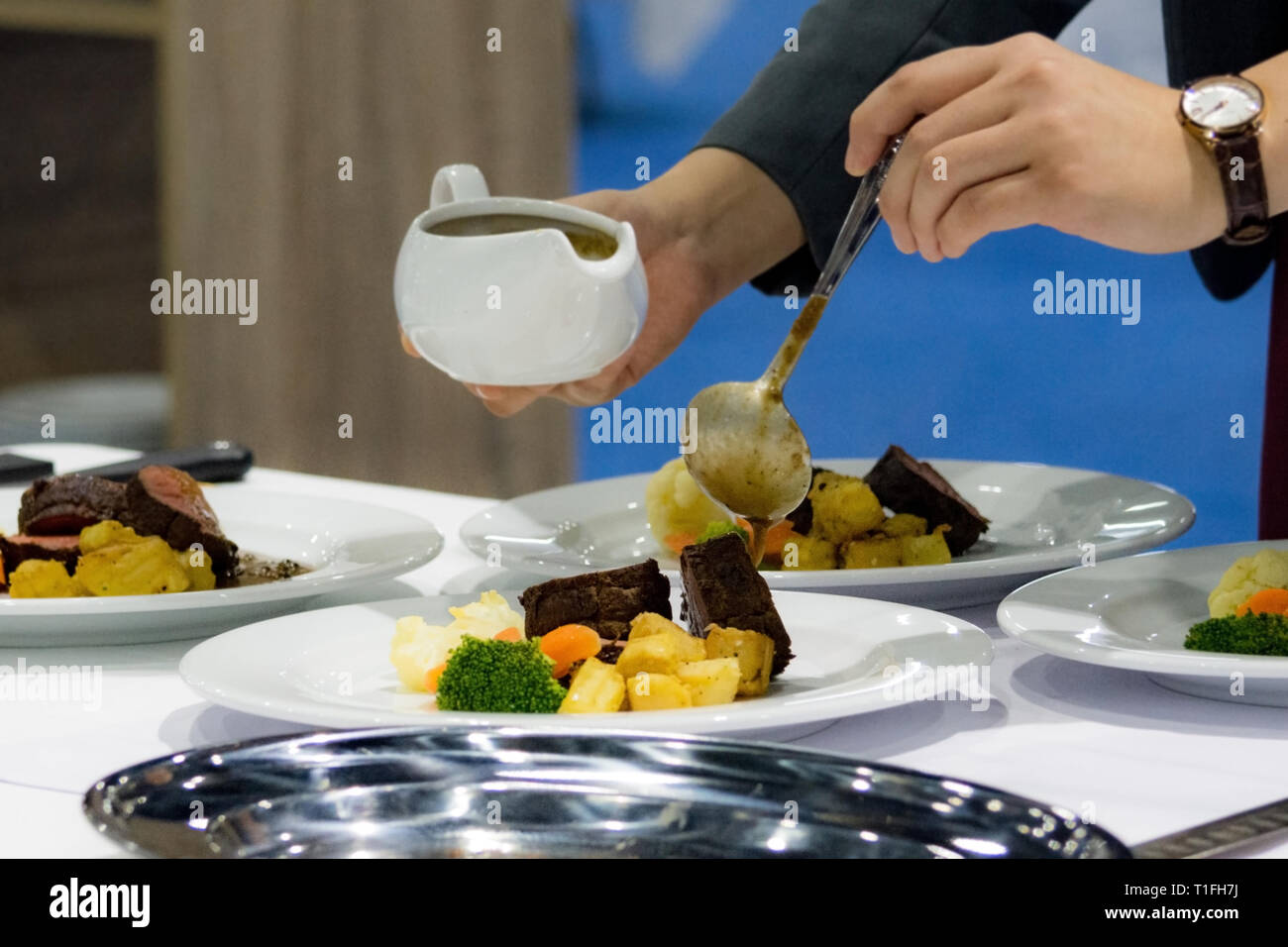 Decorating The Food In The Restaurant, Waiter is working on finishing a ...