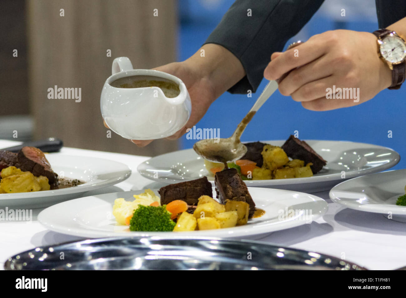 Decorating The Food In The Restaurant, Waiter is working on finishing a ...