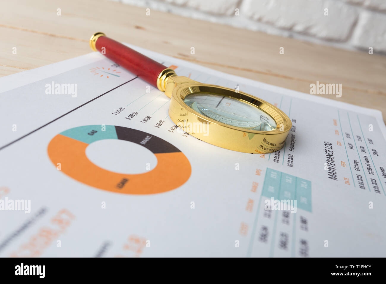Looking through magnifying glass to financial report Stock Photo - Alamy