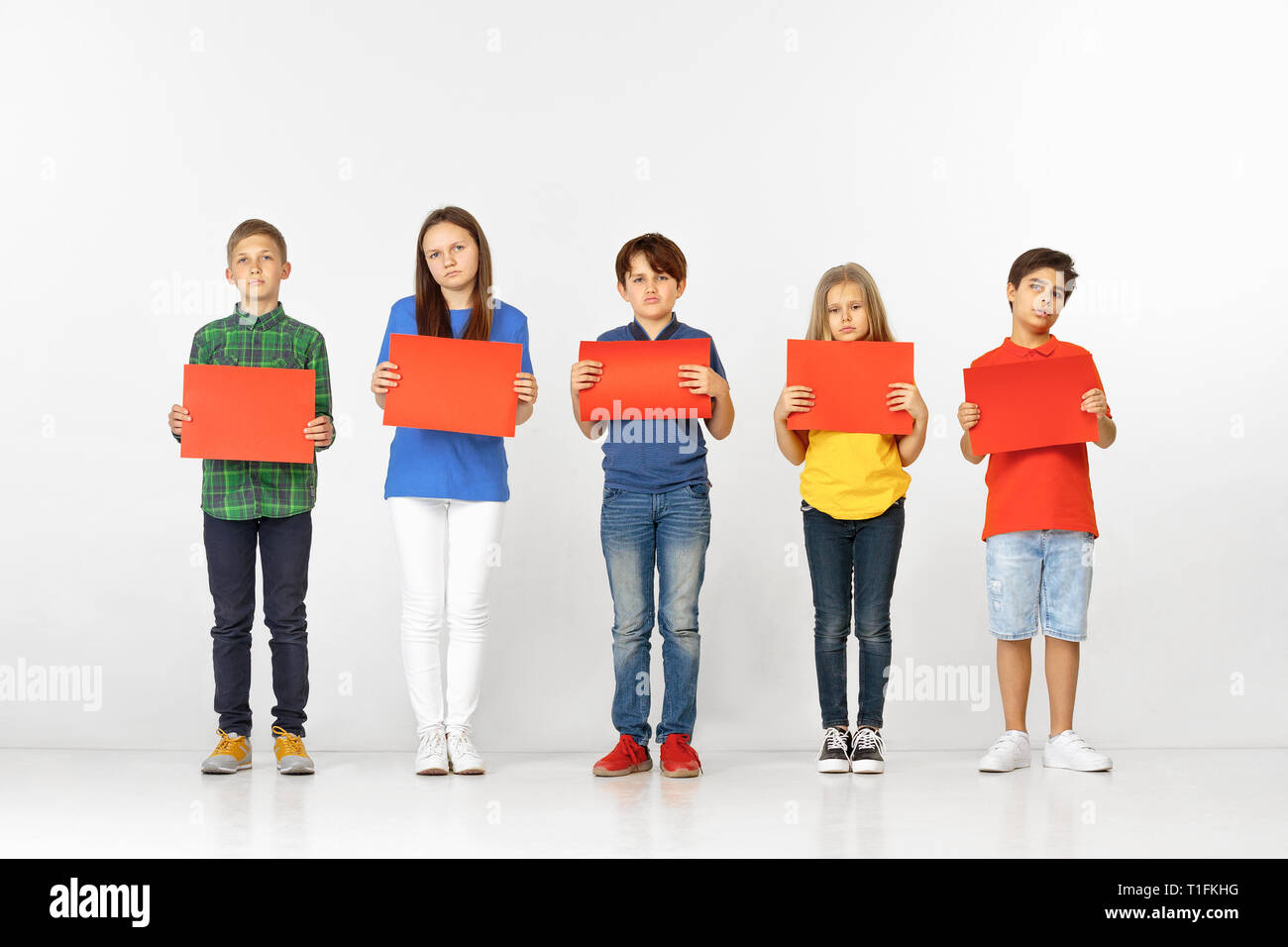 Group of sad serious children with red empty banners isolated on white ...
