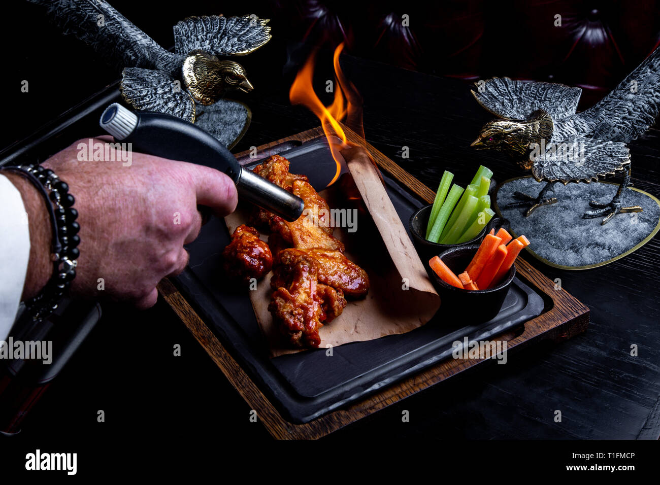 Delicious pieces of chicken wings grilled with Fire flames. On ...