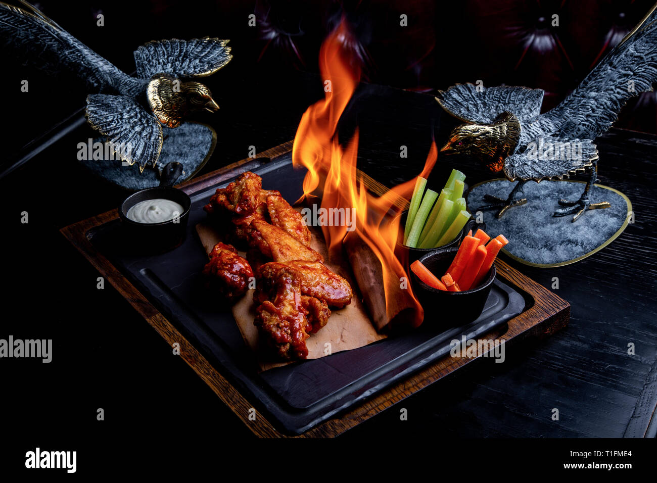 Delicious pieces of chicken wings grilled with Fire flames. On ...