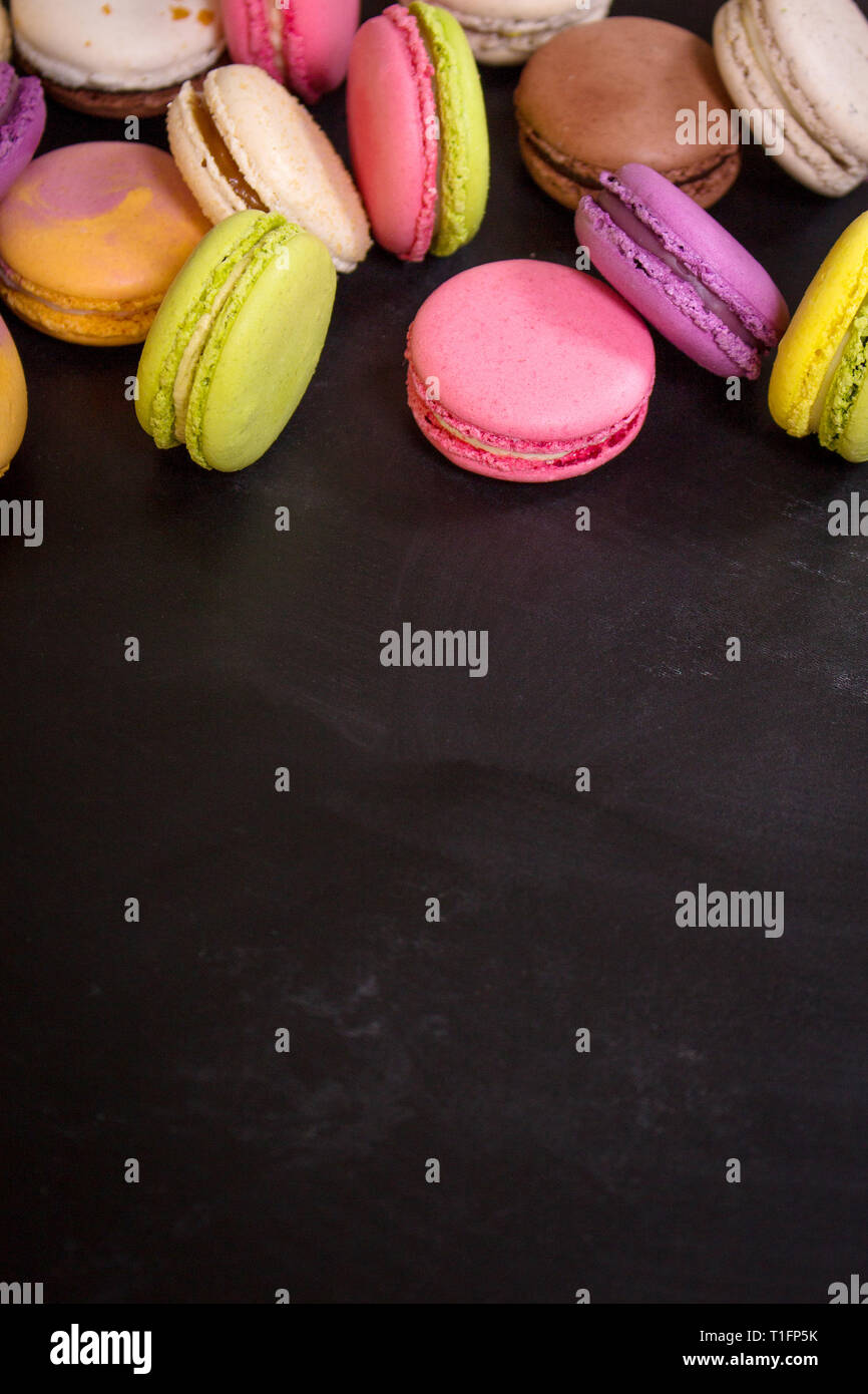 Assorted colorful macaroons on a dark background Stock Photo - Alamy