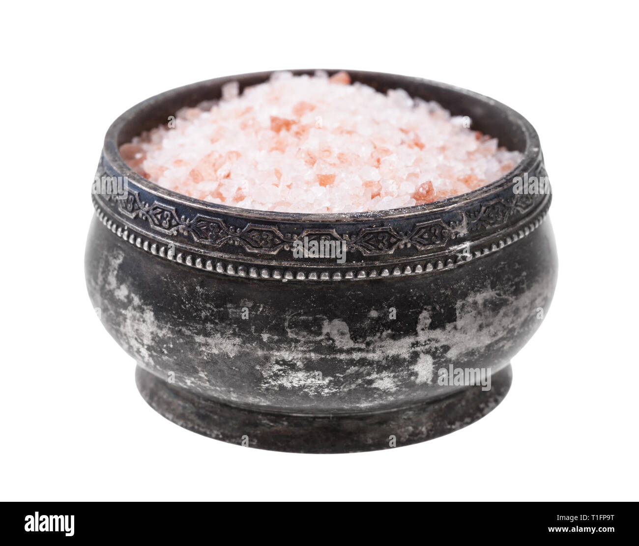 side view of old silver salt cellar with pink Himalayan Salt isolated ...